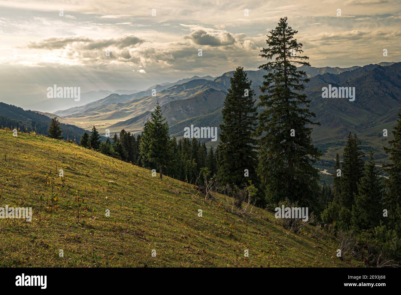 Sun shining through the clouds over a valley in northern Kyrgyzstan ...