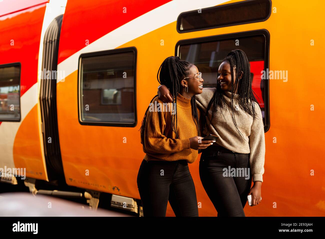 Female friends walking at train station Stock Photo - Alamy