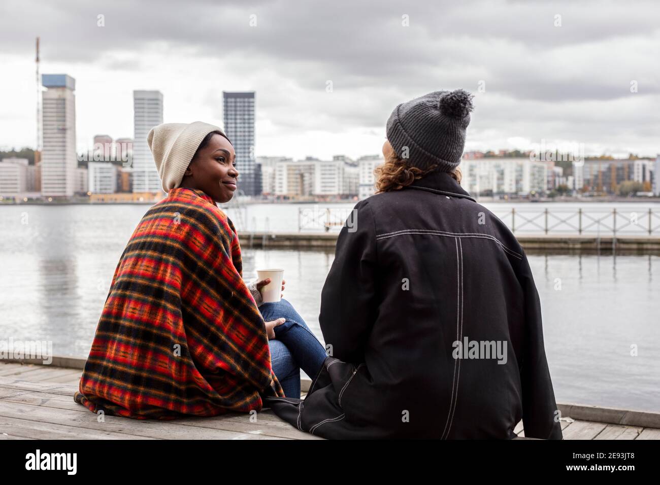 Female friends talking at sea Stock Photo - Alamy