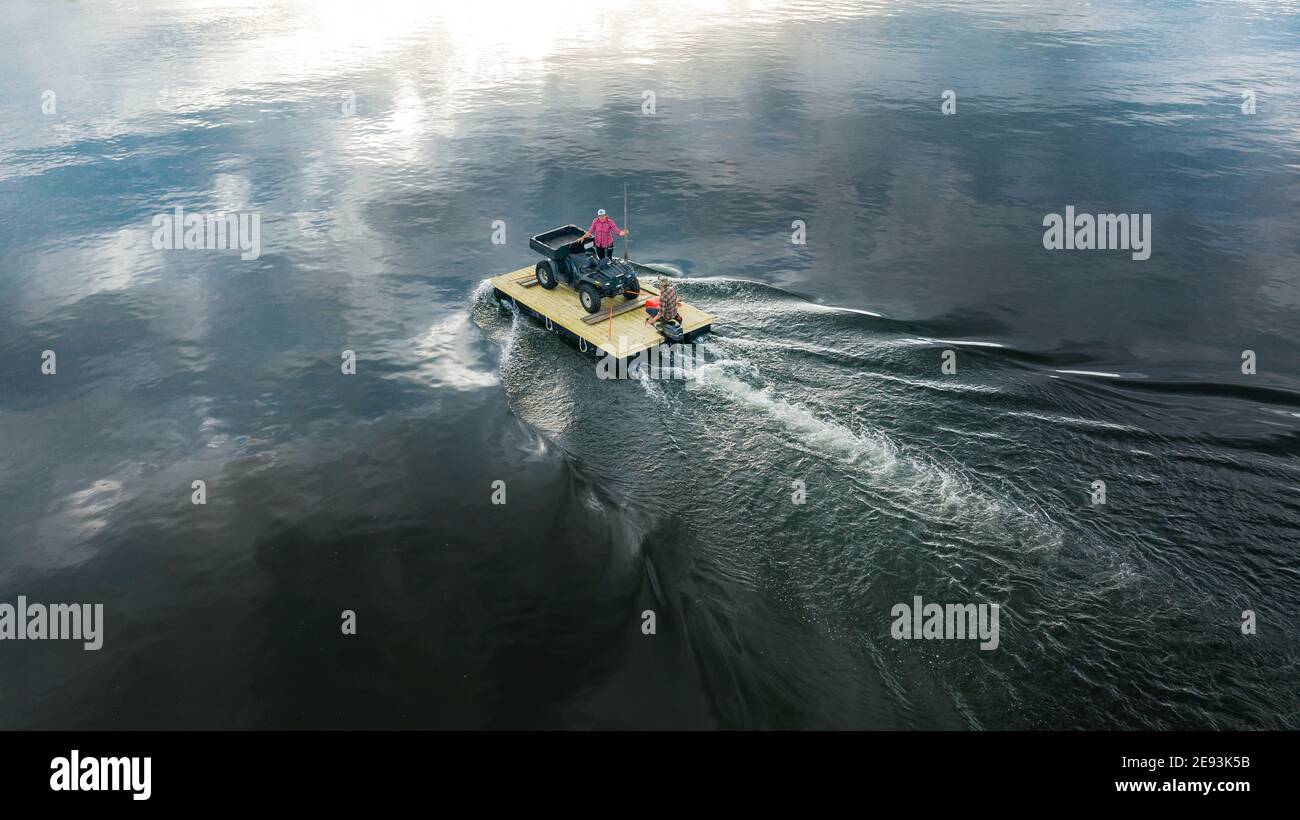 Couple transporting quadbike on motor raft Stock Photo - Alamy