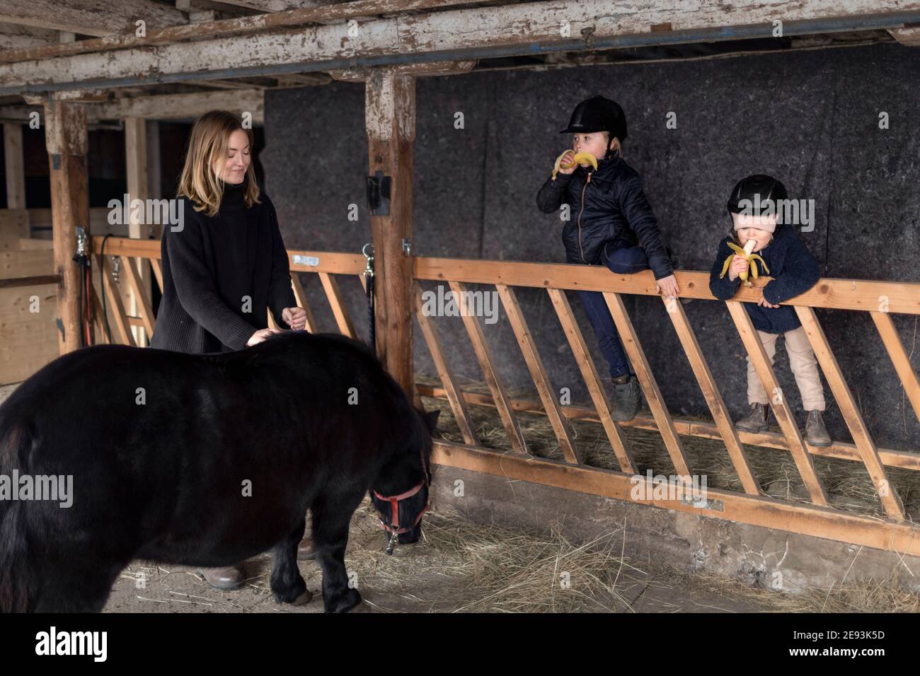 Mother and daughters in stable Stock Photo - Alamy