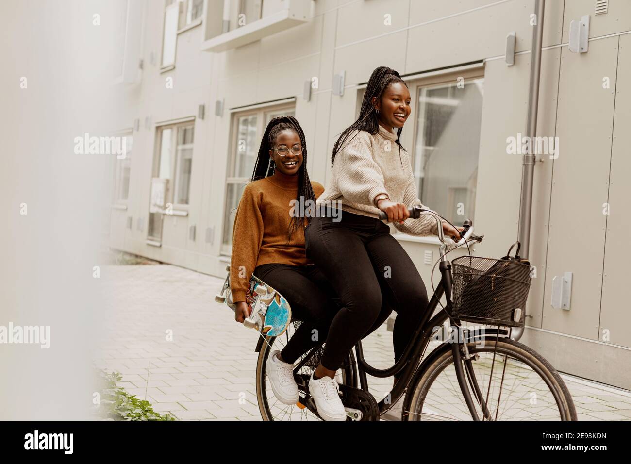 Happy female friends on bicycle Stock Photo - Alamy