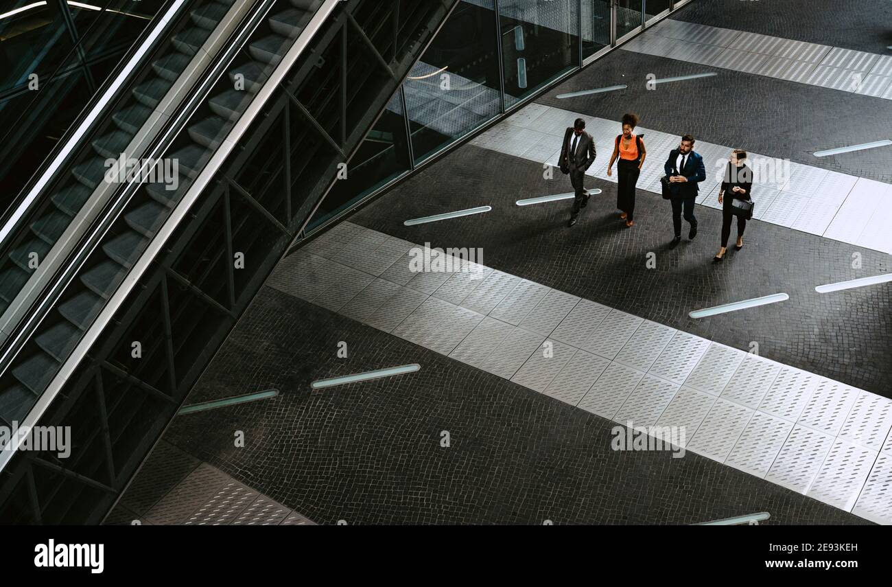 High angle view of male entrepreneurs discussing with female colleagues ...