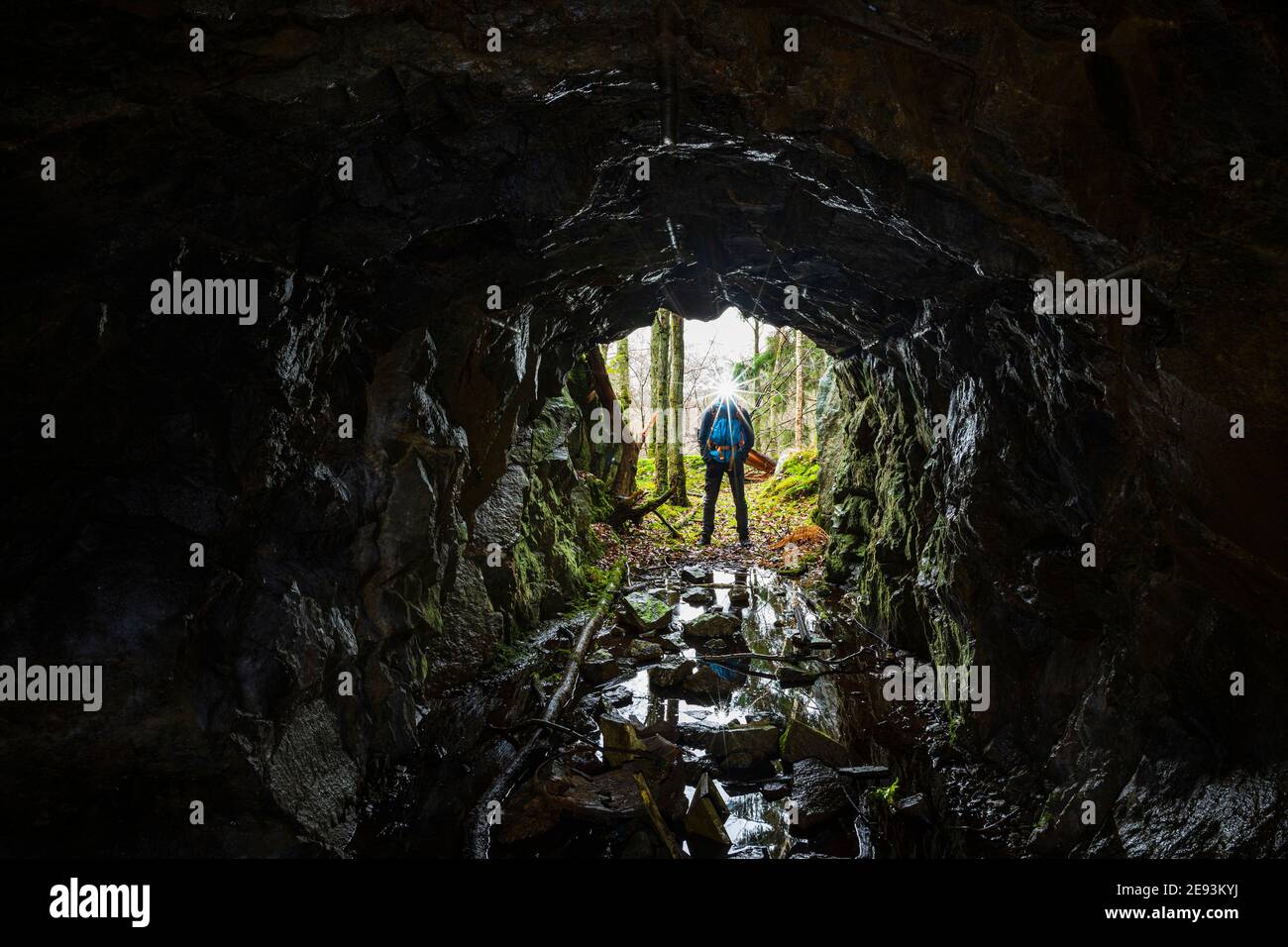Spelunker with headlamp standing at cave entrance Stock Photo - Alamy