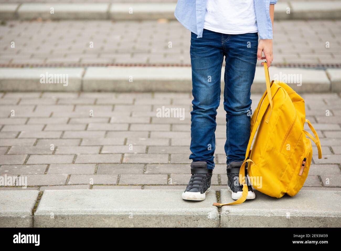 Low section of boy holding backpack Stock Photo - Alamy