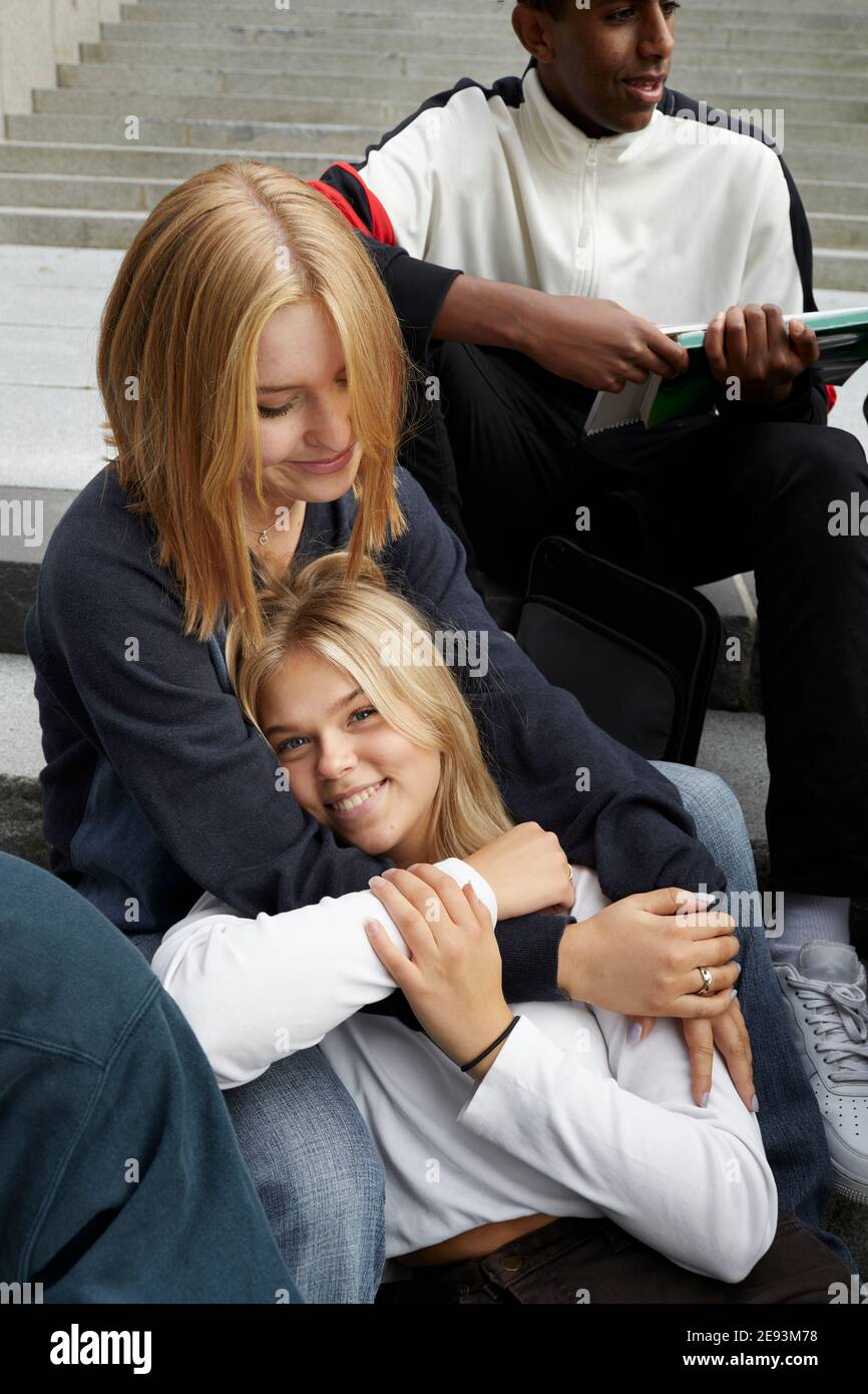 Teenage friends sitting together Stock Photo - Alamy