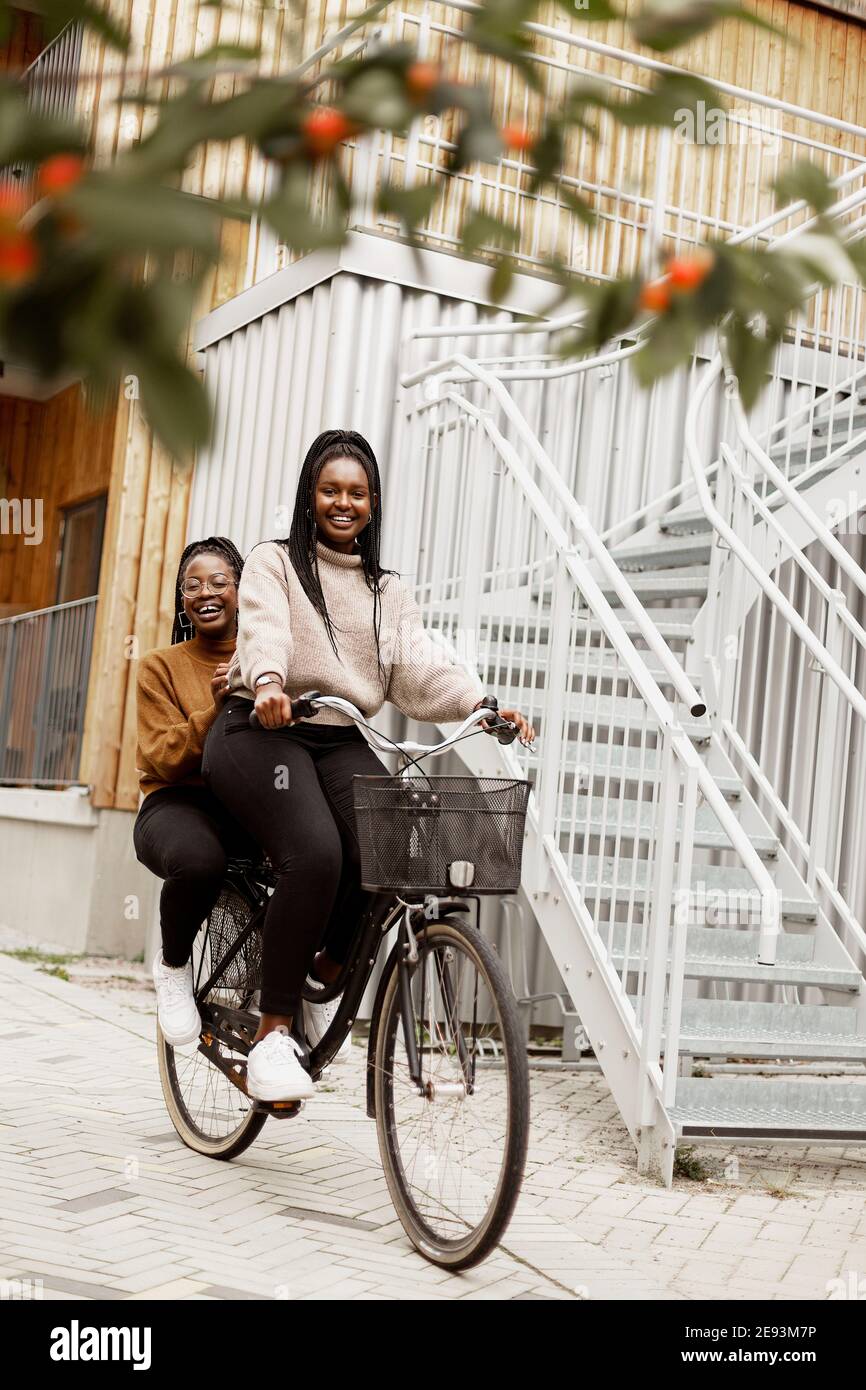 Happy female friends on bicycle Stock Photo - Alamy