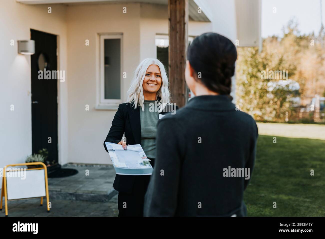 Female estate agent showing woman documents Stock Photo - Alamy