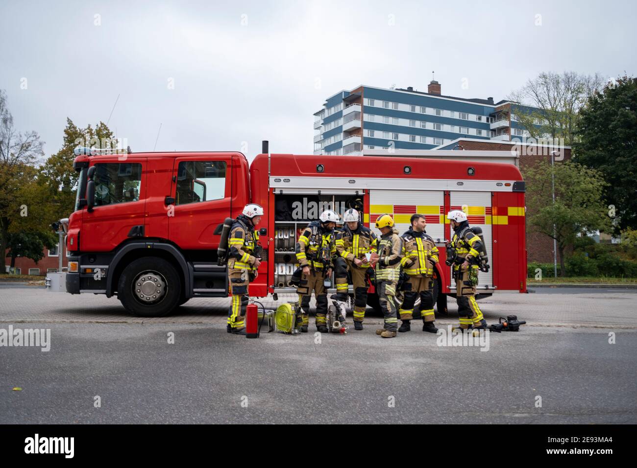 Firefighters team in front of fire engine Stock Photo - Alamy