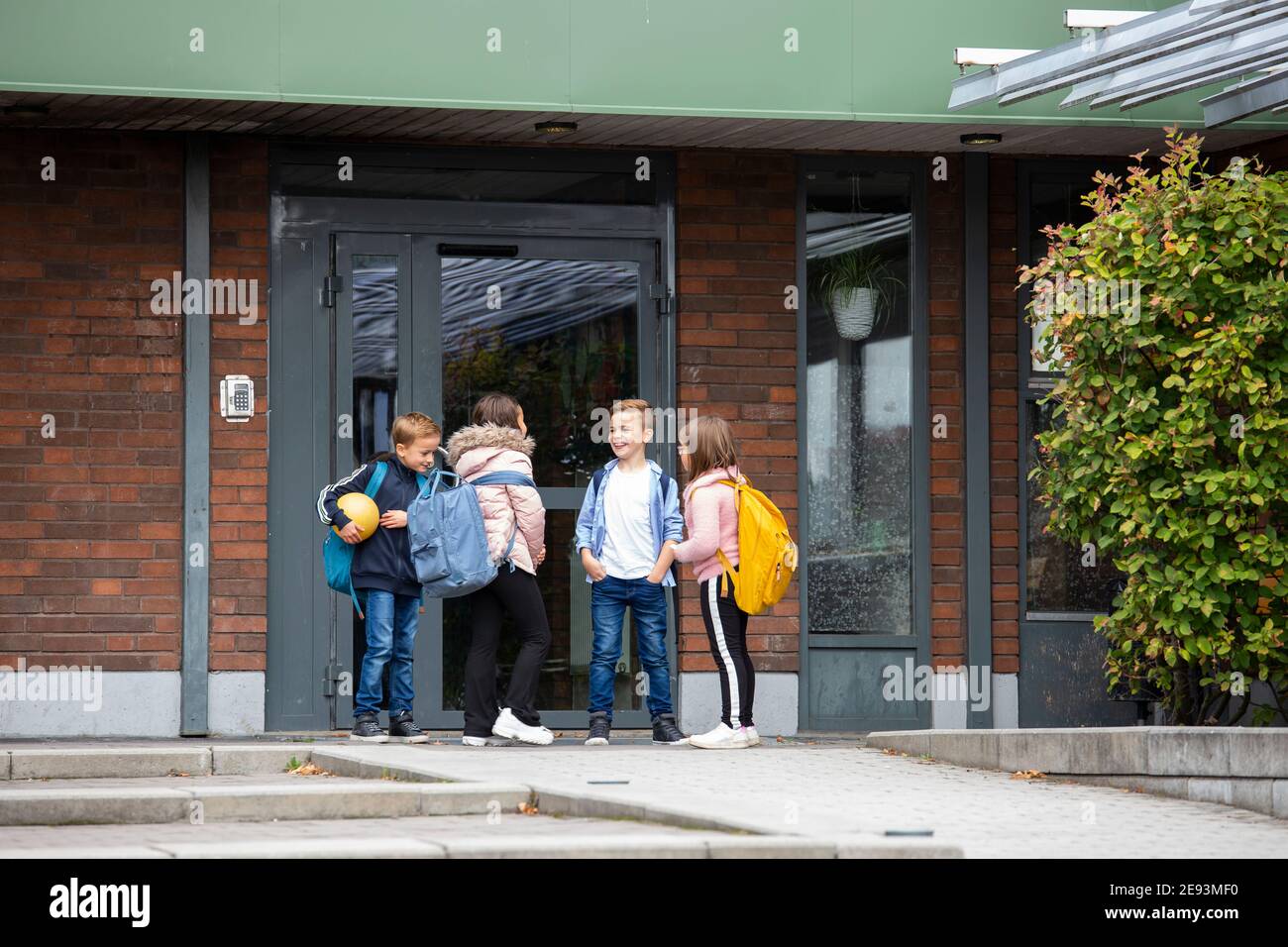 Children talking in front of school building Stock Photo - Alamy