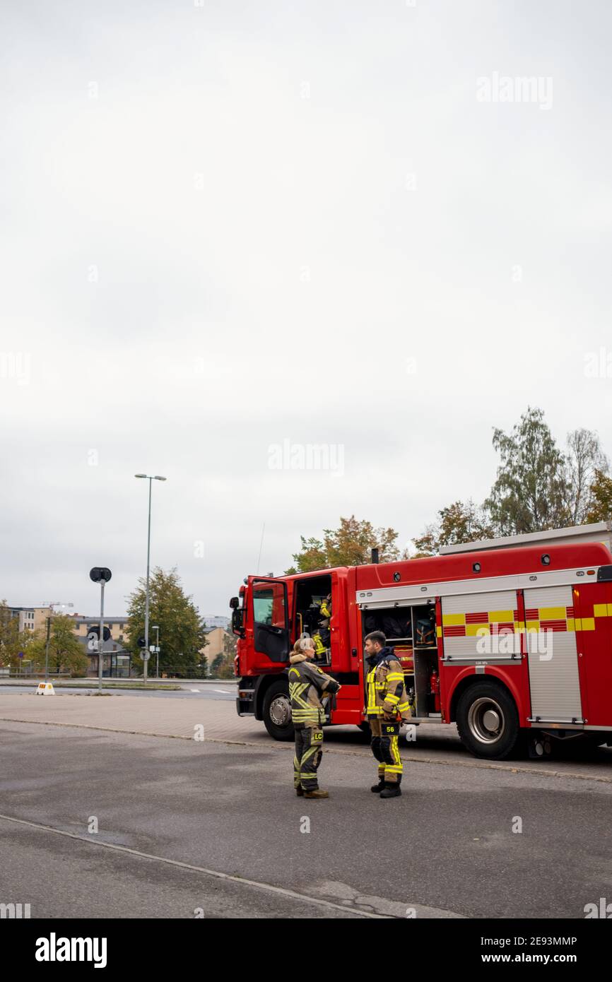 Firefighters in front of fire engine Stock Photo - Alamy