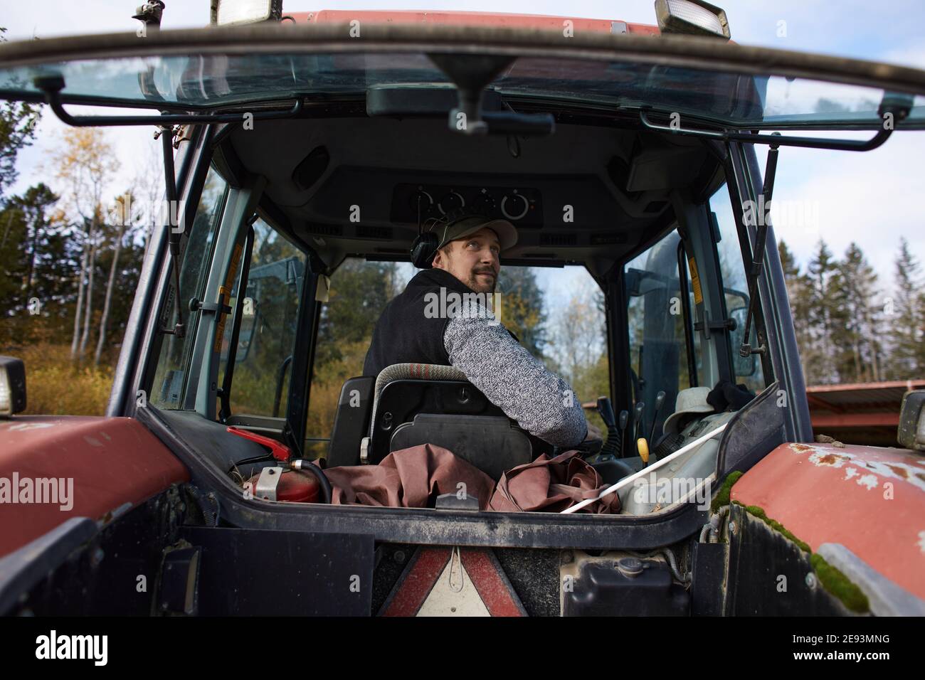 Farmer driving tractor Stock Photo - Alamy