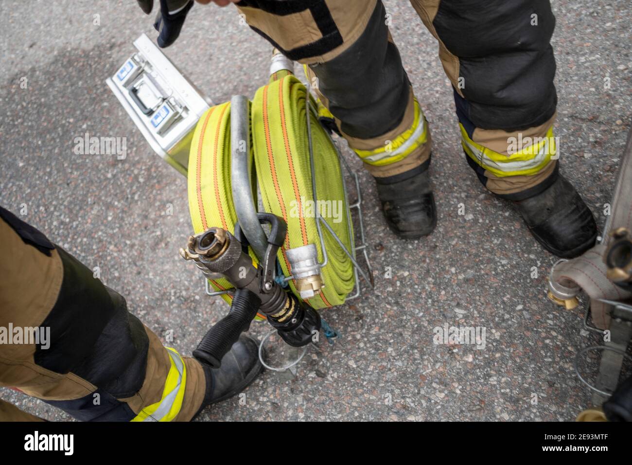 Low section of firefighter standing by fire hose Stock Photo - Alamy