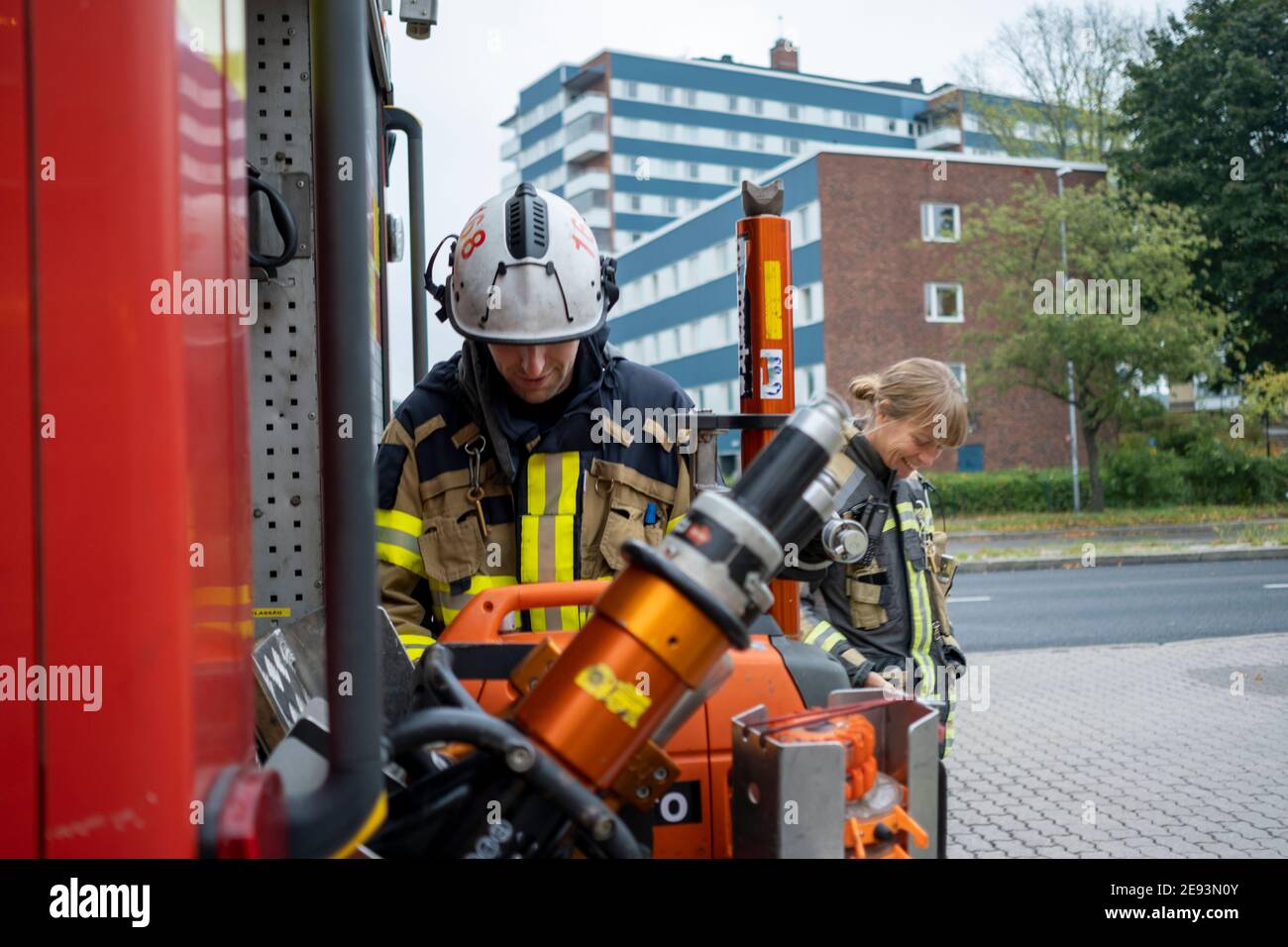 Firefighters preparing near fire engine Stock Photo - Alamy
