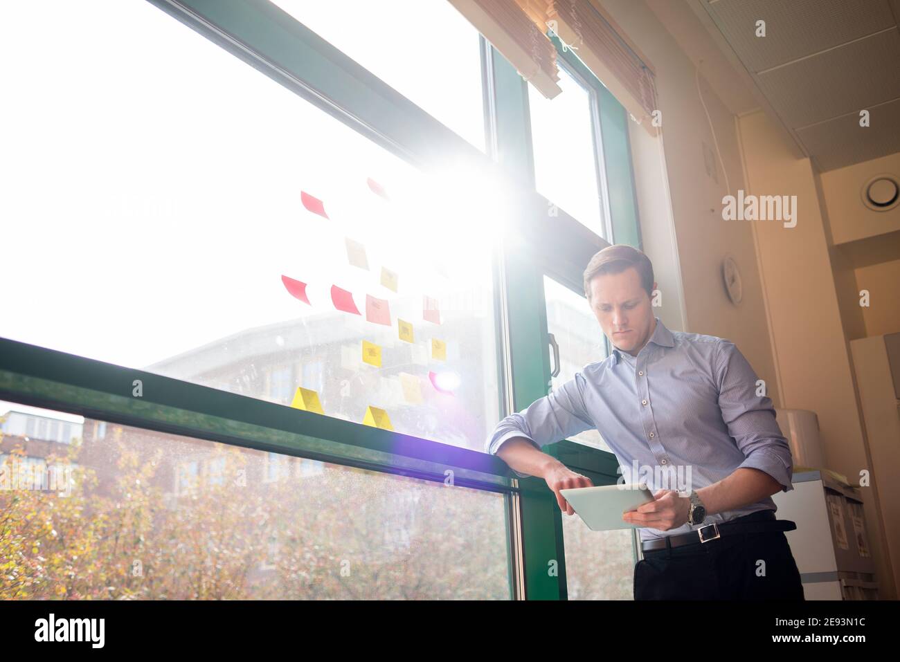 Man standing against window Stock Photo - Alamy