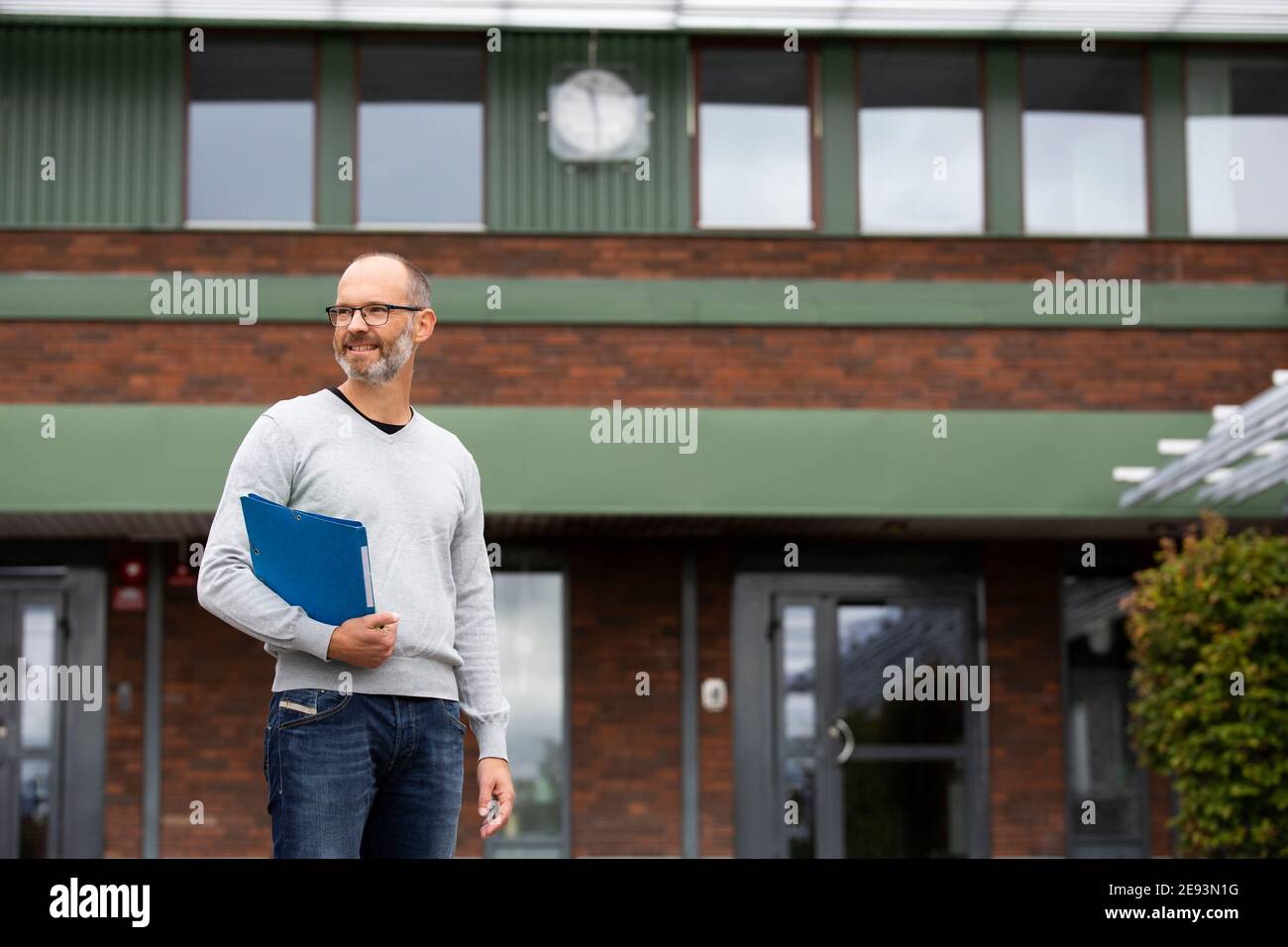 Teacher standing in front of school Stock Photo - Alamy