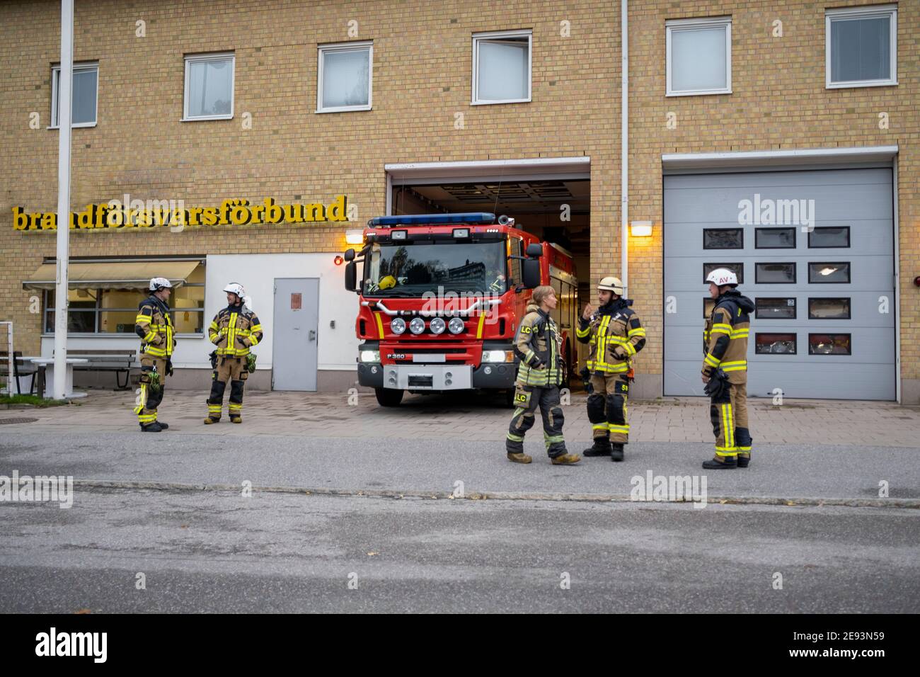 Firefighters in front of fire station Stock Photo - Alamy