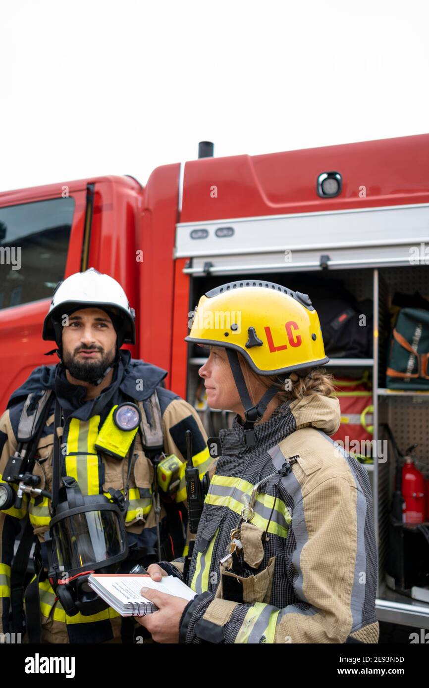Firefighters in front of fire engine Stock Photo - Alamy