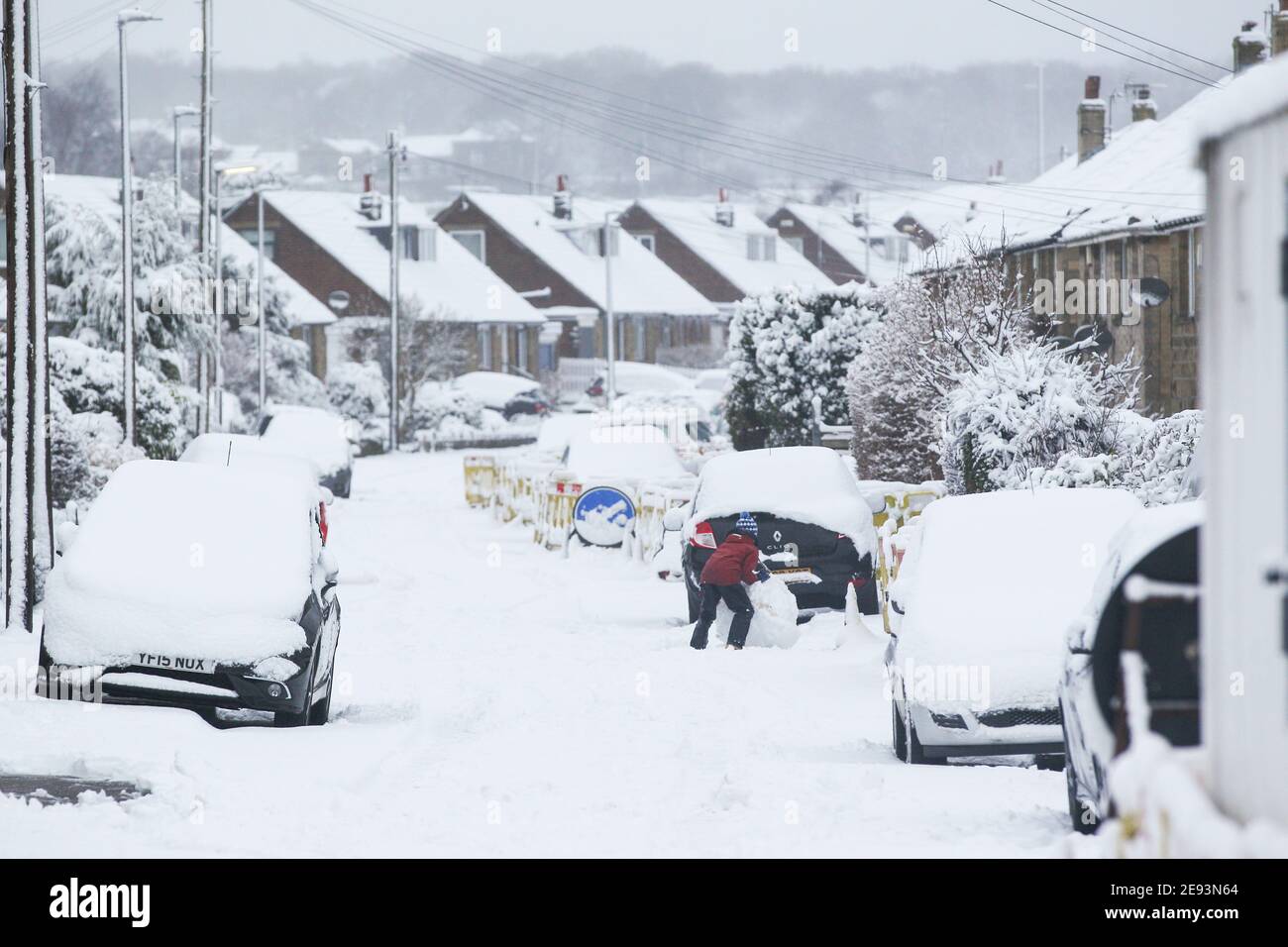 A child rolls a snowball in the West Yorkshire village of Honley. Heavy ...