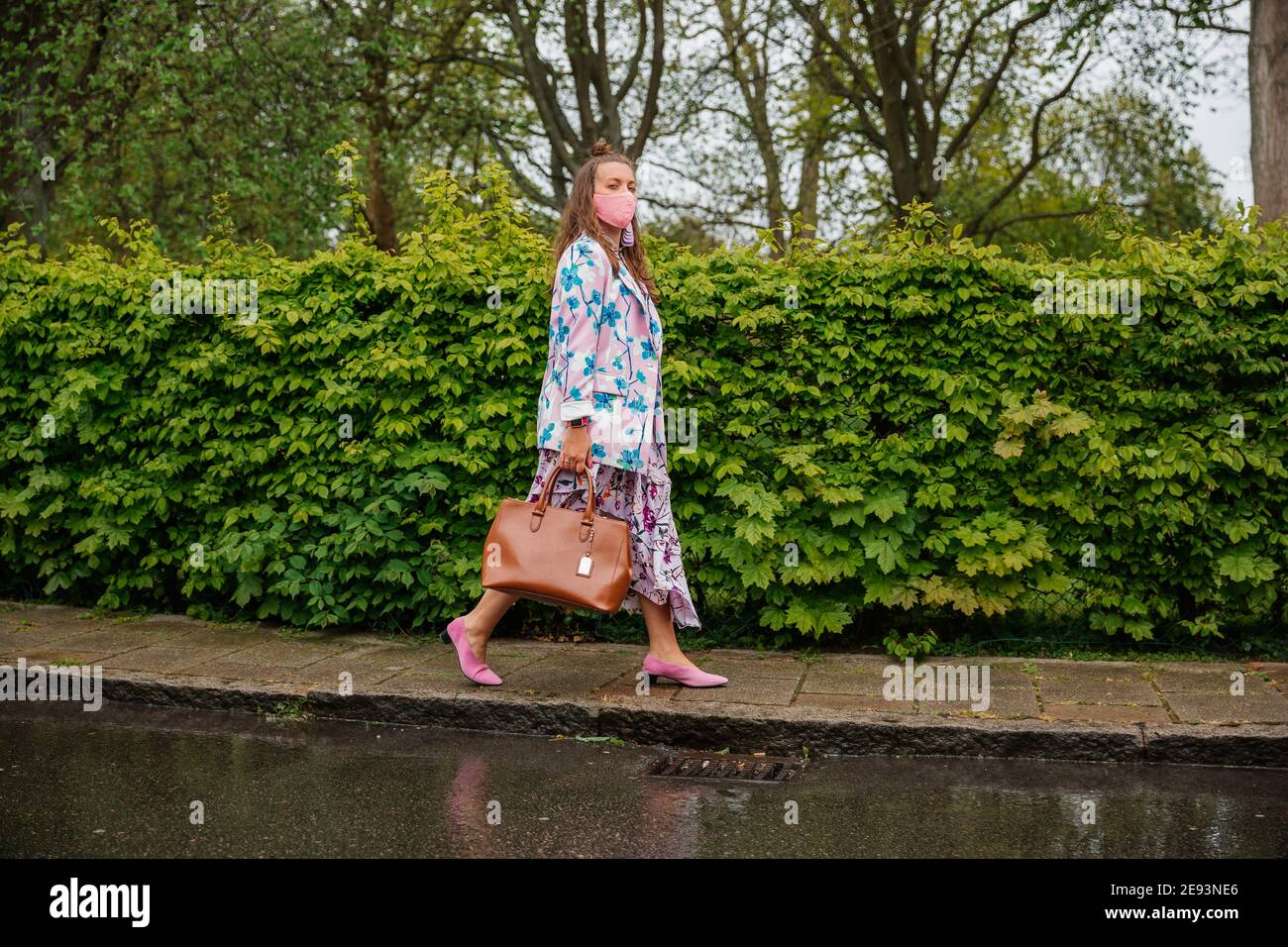 Woman walking on sidewalk wearing face mask Stock Photo - Alamy