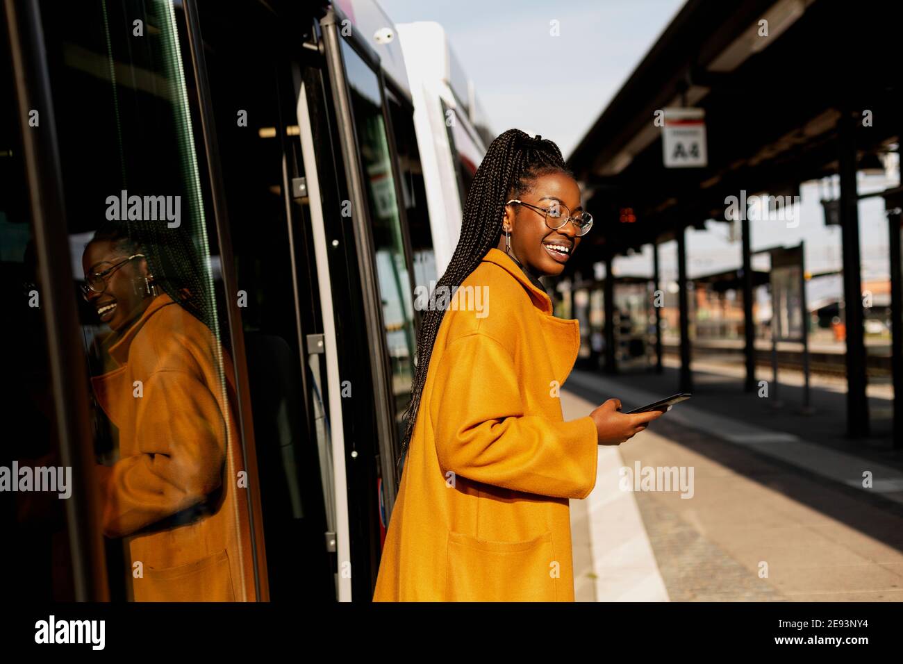 Smiling woman leaving bus at bus station Stock Photo - Alamy