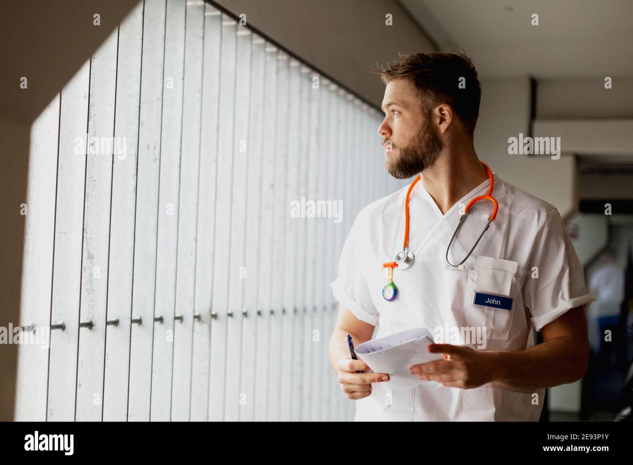 Doctor in hospital looking through window Stock Photo - Alamy