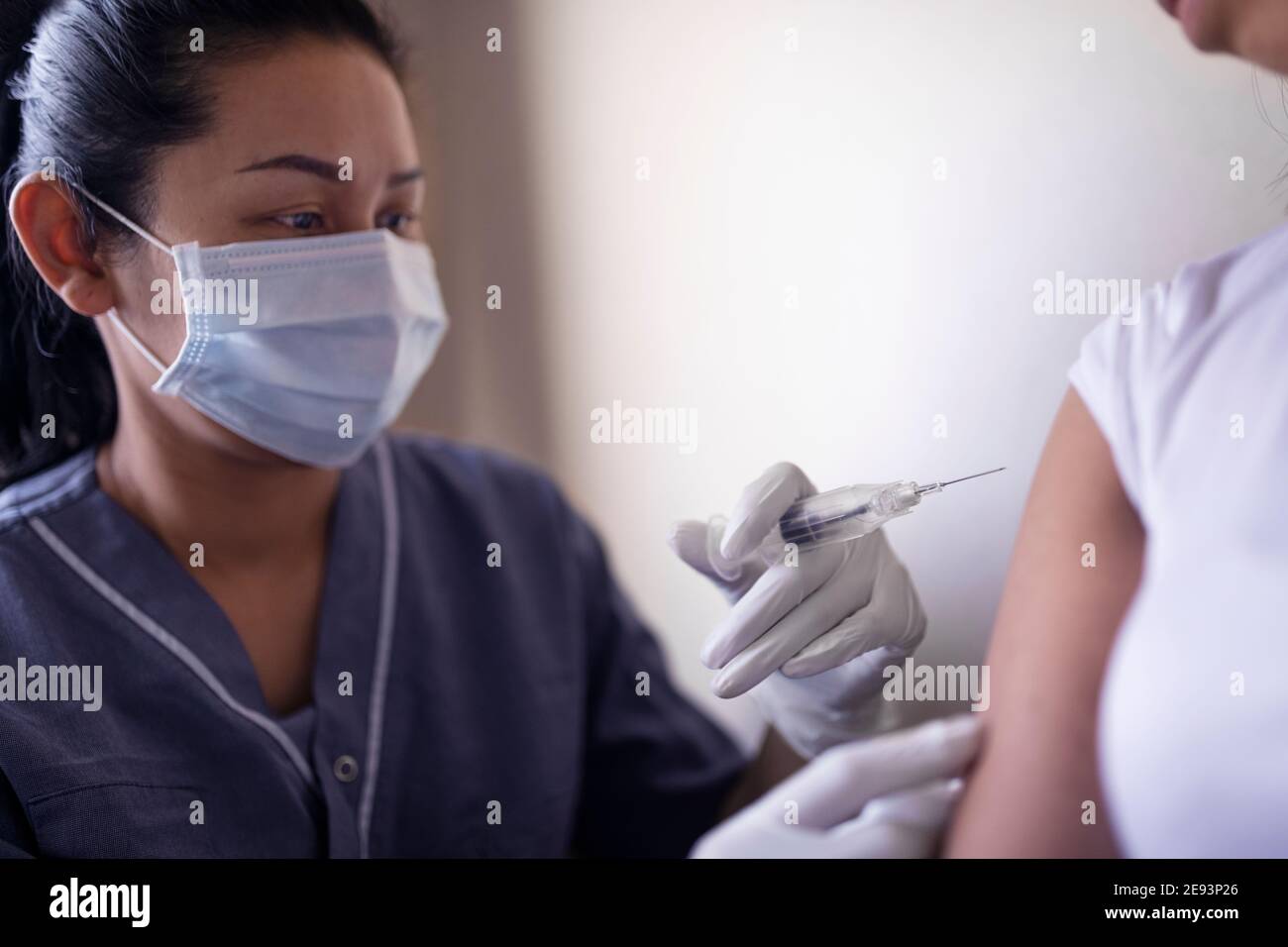Woman receiving injection in her arm Stock Photo - Alamy
