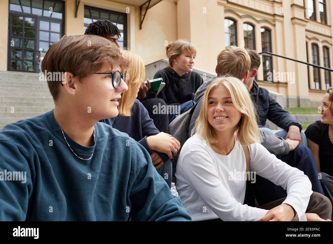 Teenagers talking together in front of school Stock Photo - Alamy