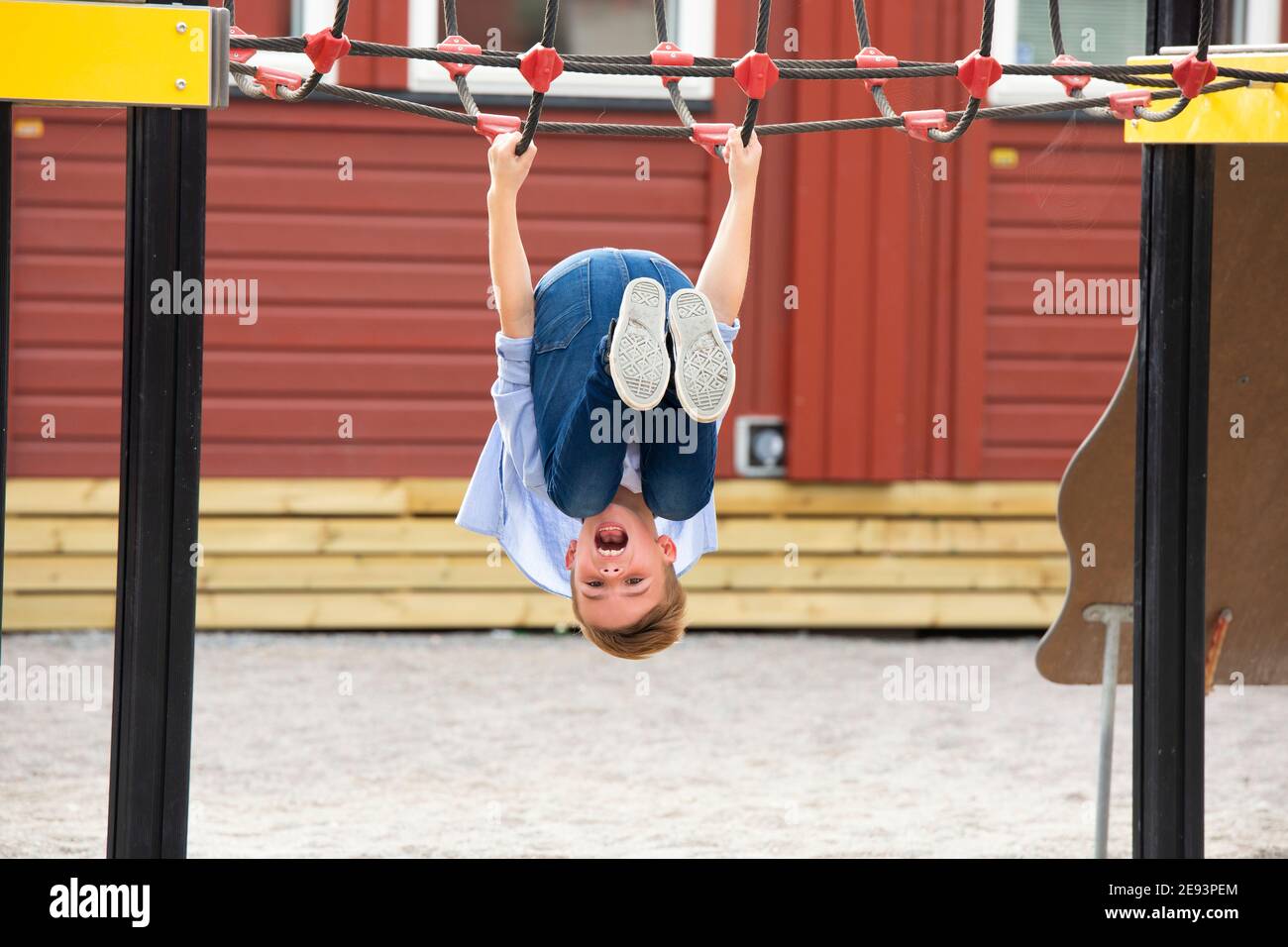 Boy playing on monkey bars Stock Photo - Alamy