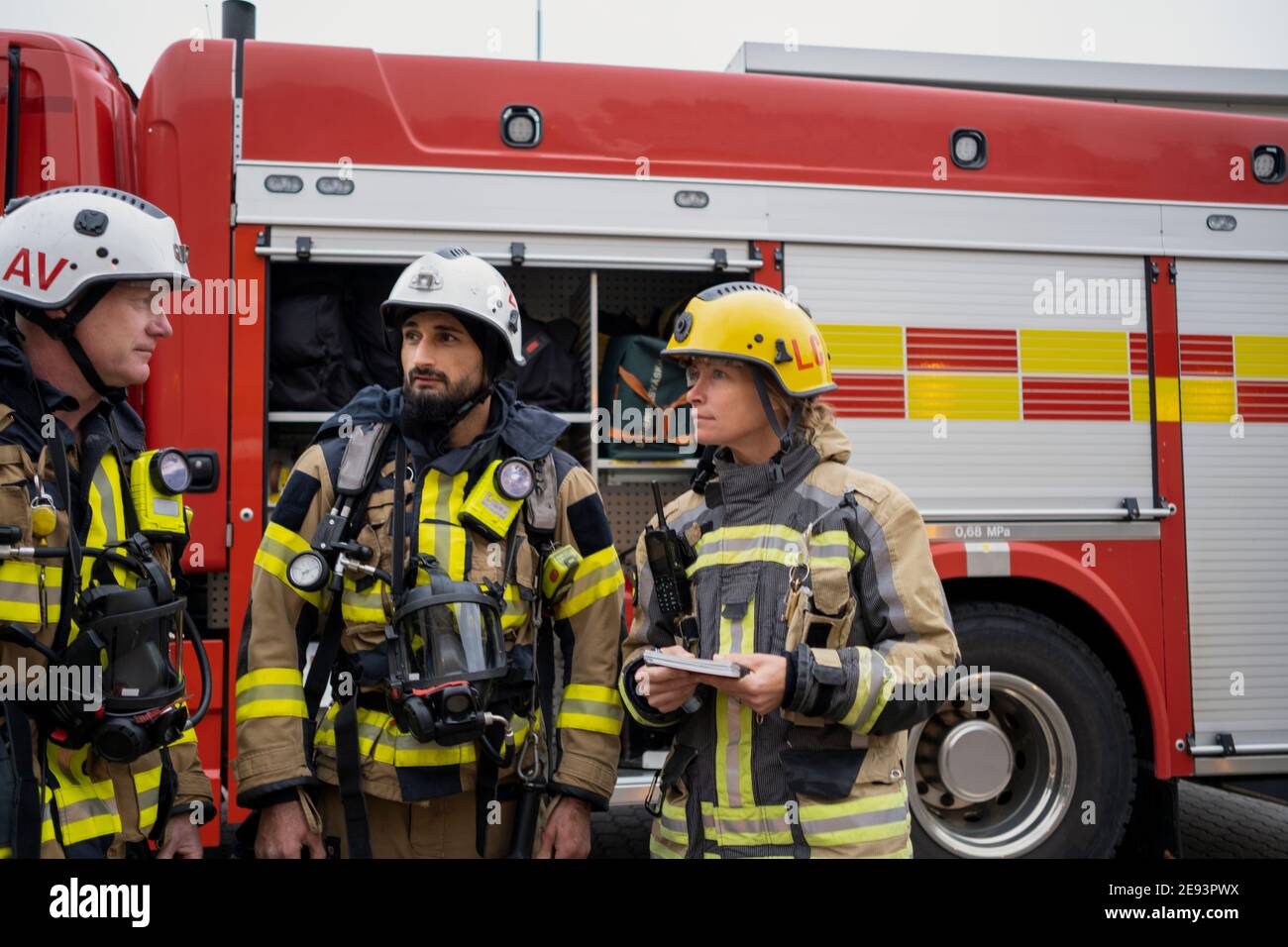 Firefighters in front of fire engine Stock Photo - Alamy