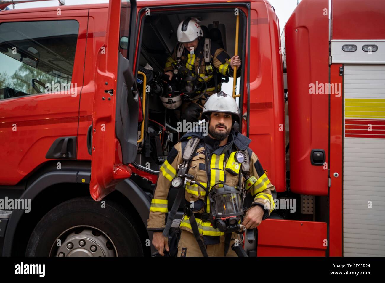 Firefighter in front of fire engine Stock Photo - Alamy