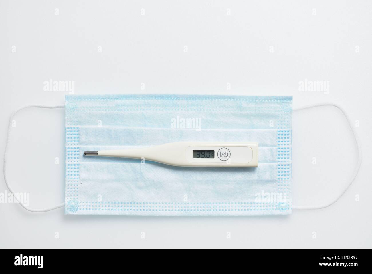 Electronic thermometer with high temperature lies on a face mask Stock ...