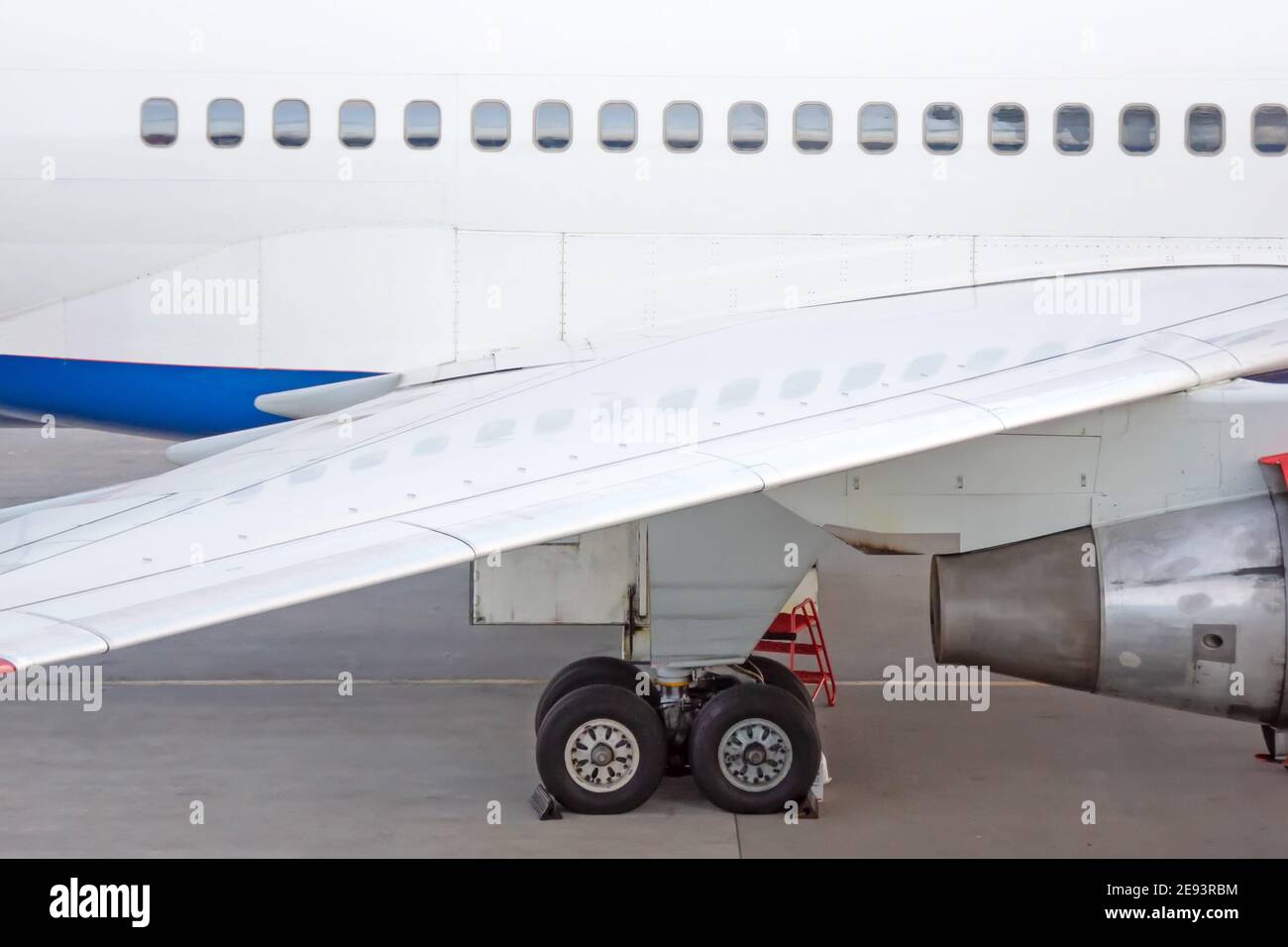 Engine on white fuselage with portholes of passenger plane, jet turbine ...