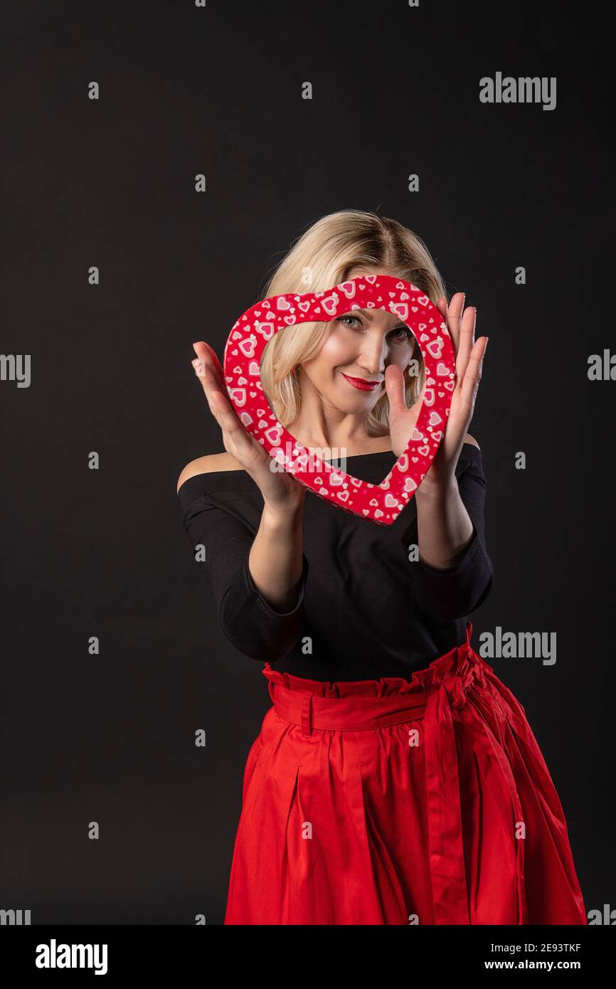 Girl holds a heart at eye level Valentine symbol, design, on the floor ...