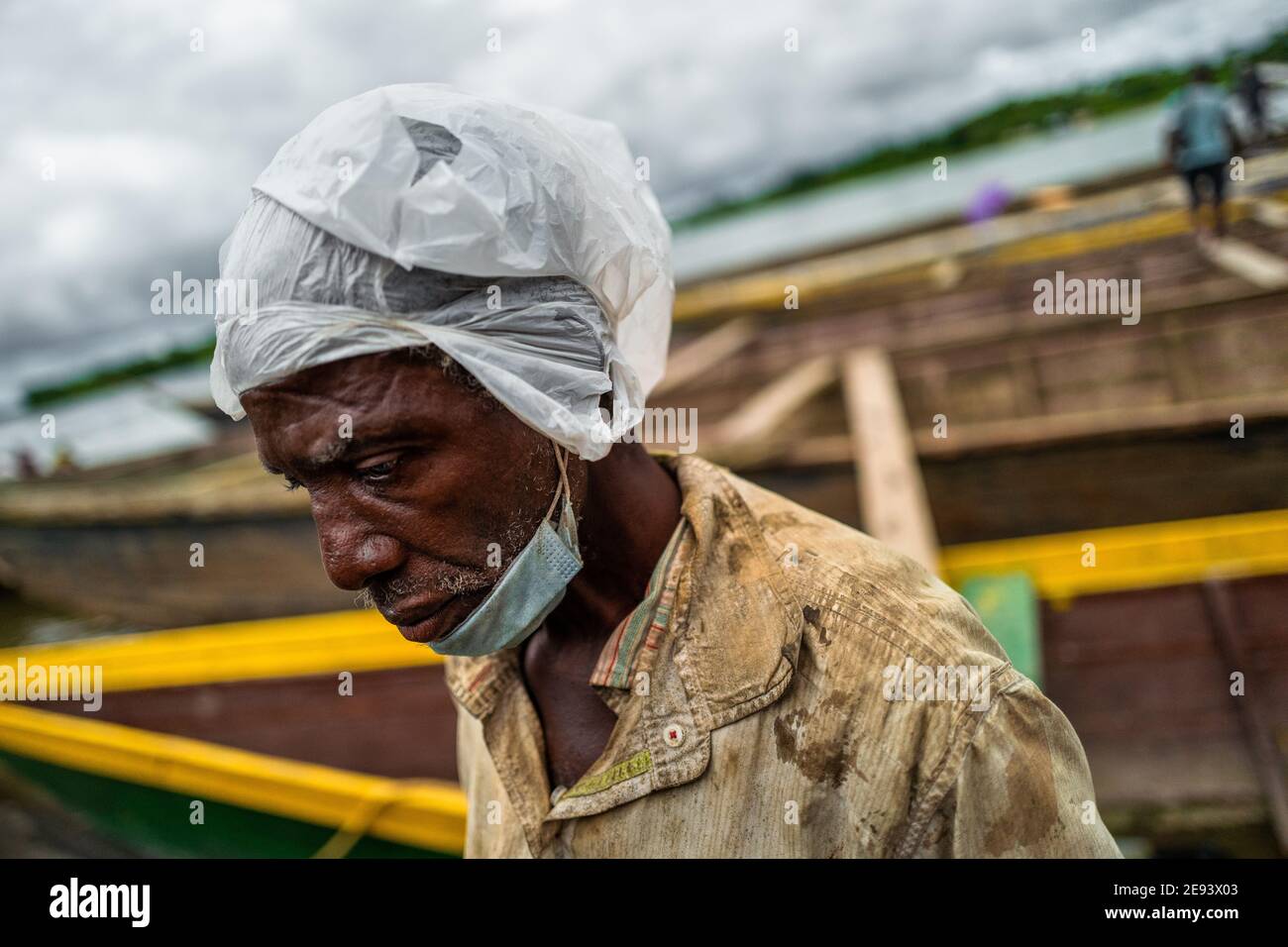 An Afro-Colombian worker walks on the top of wooden cargo boats ...