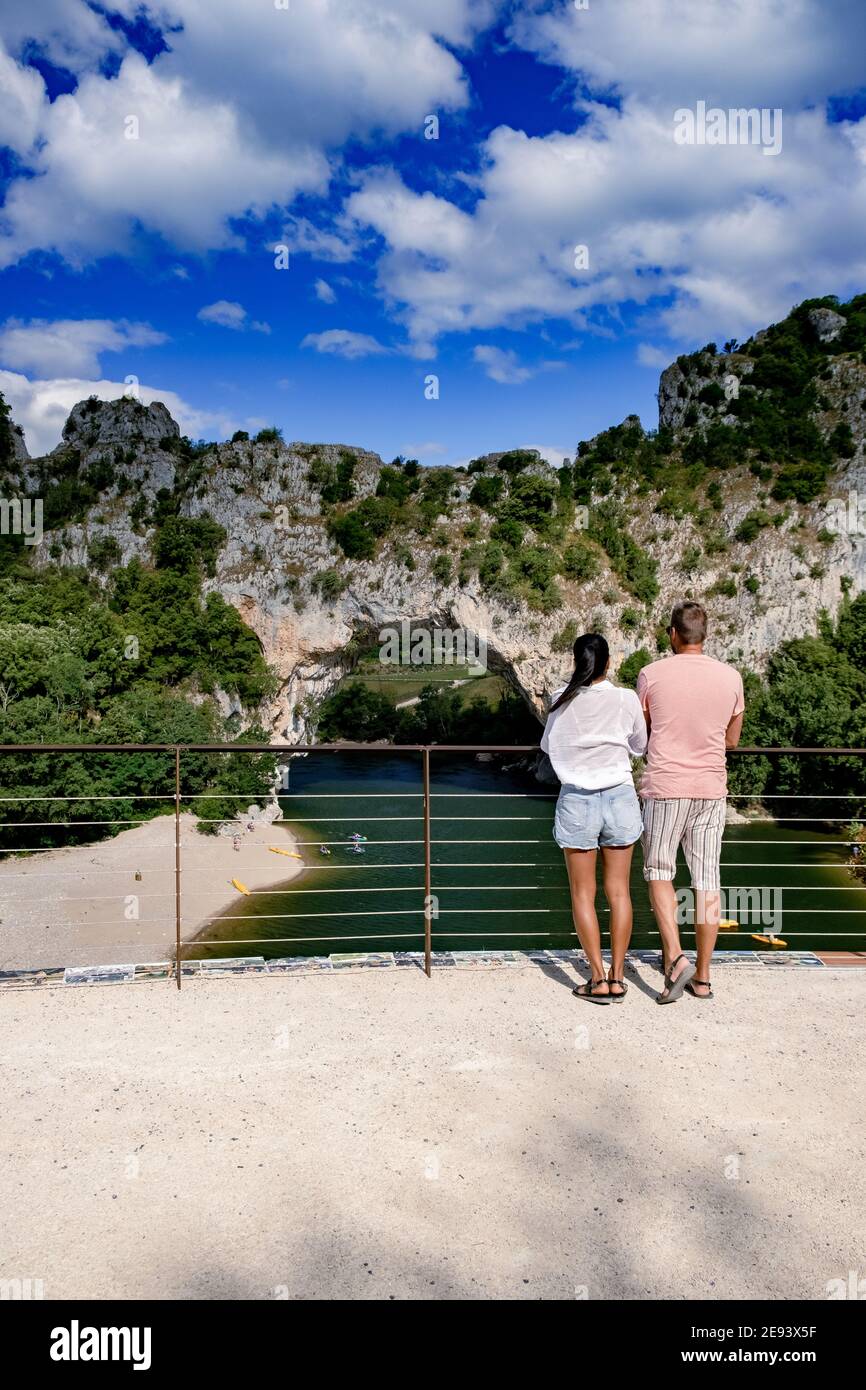 couple men and woman visiting The famous natural bridge of Pont d'Arc ...
