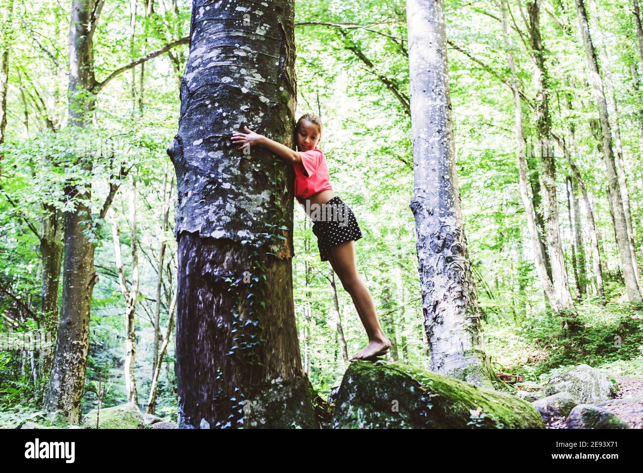 Connecting With Nature. Little girl embracing tree in the woods. Love ...