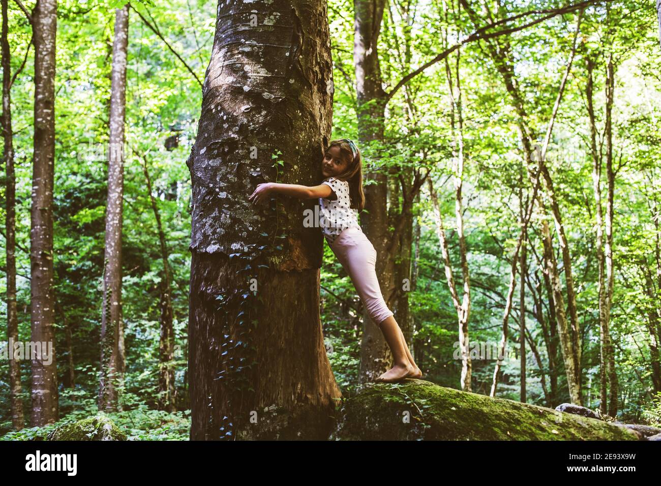 Connecting With Nature. Little girl embracing tree in the woods. Love ...
