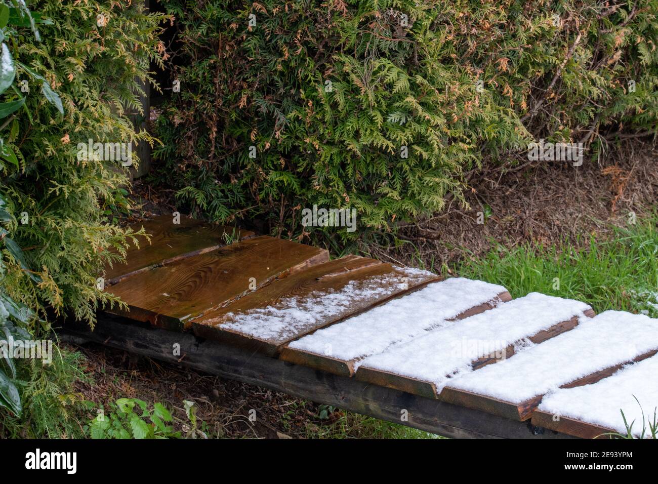 A small wooden footbridge over a ditch leads to a wooden gate in the ...