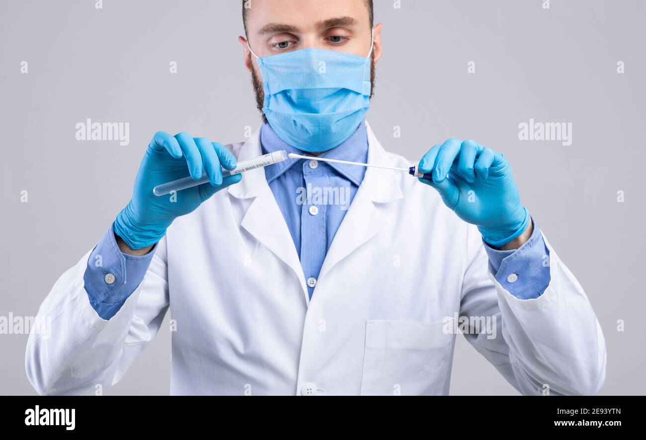 Medical doctor in face mask and gloves holding covid-19 PCR test tube ...