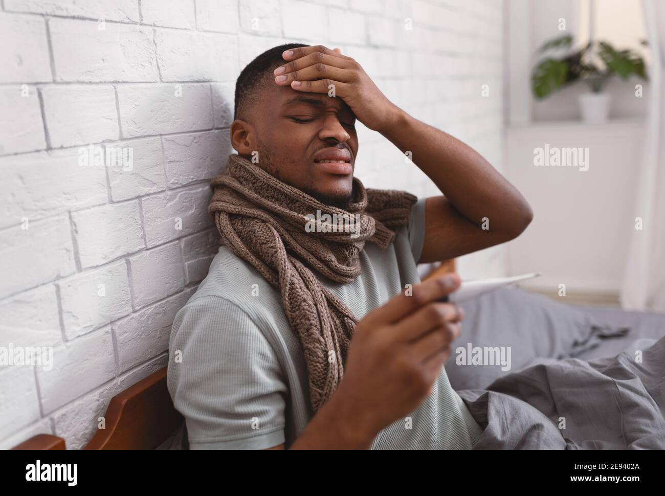 Guy Holding Thermometer Having Fever Sitting In Bed At Home Stock Photo ...