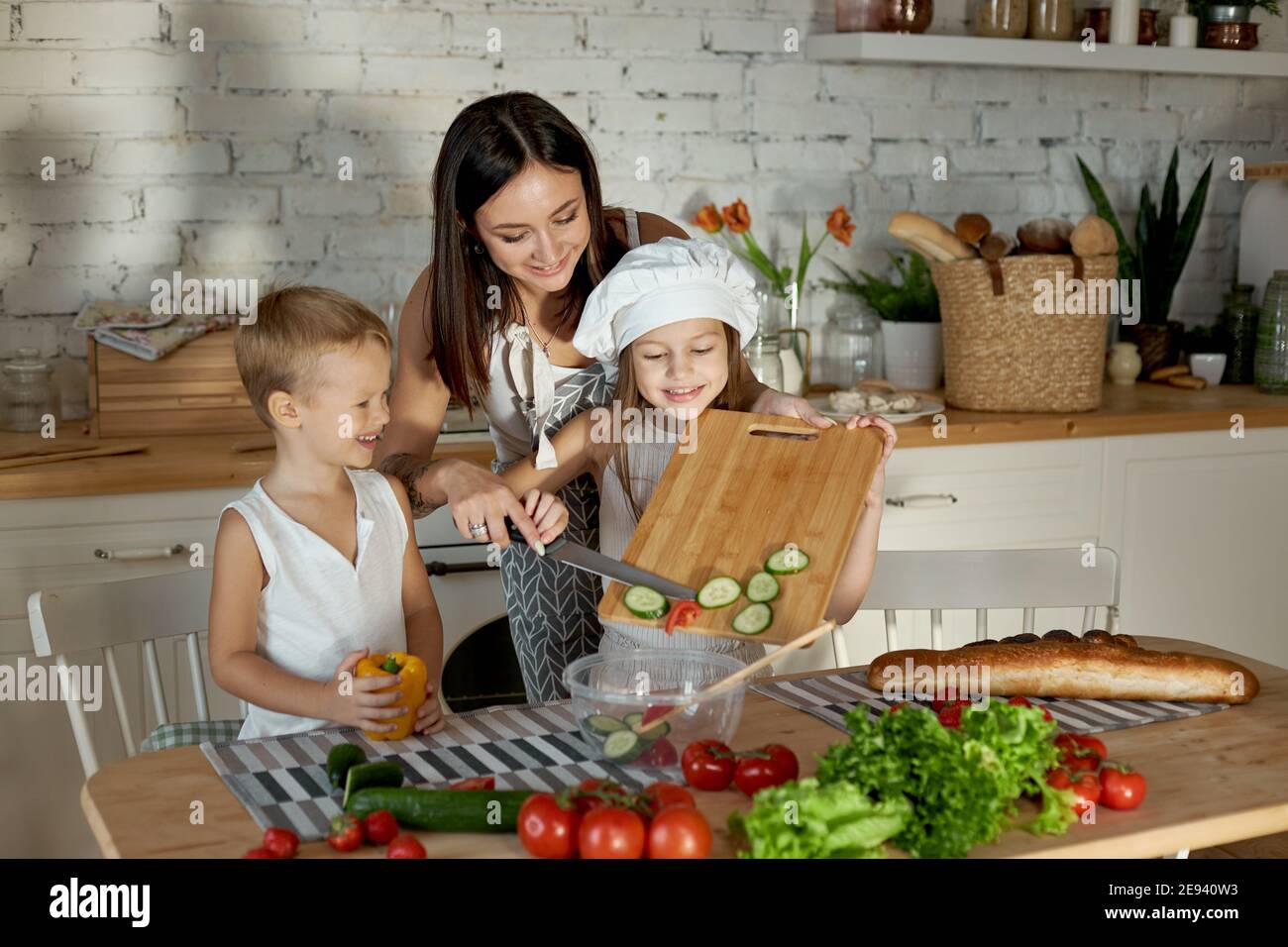 Mom cooks lunch with the kids. A woman teaches her daughter to cook ...