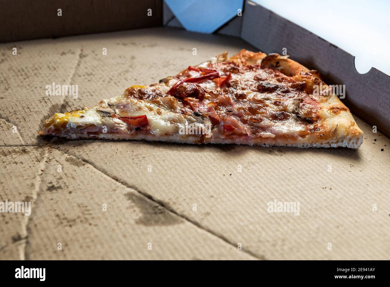 Last slice of pizza in a delivery cardboard box. Concept for home ...