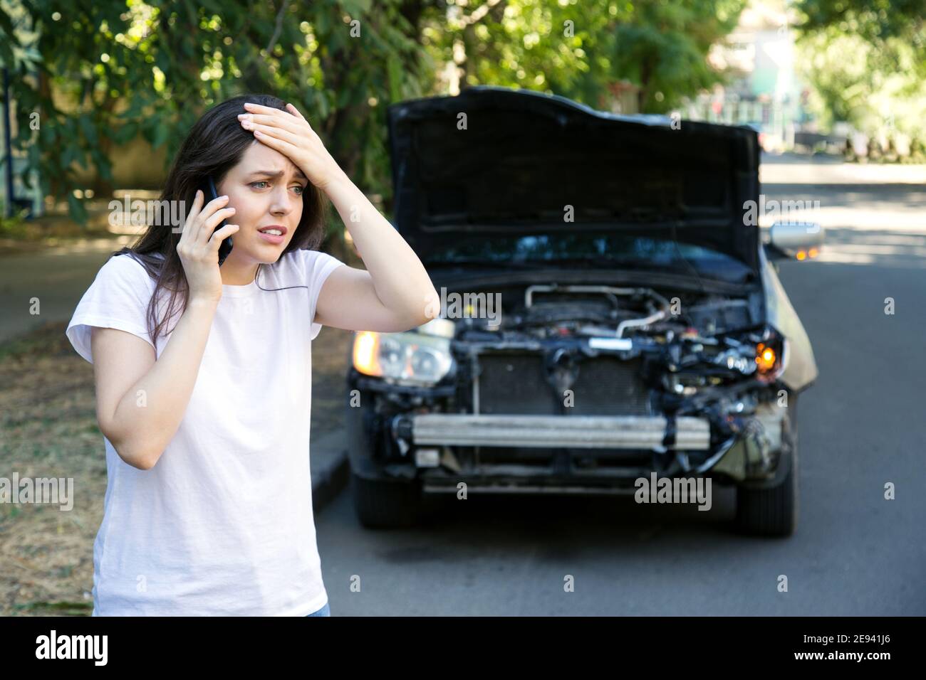 Driver woman in front of wrecked car in car accident. Scared woman in ...
