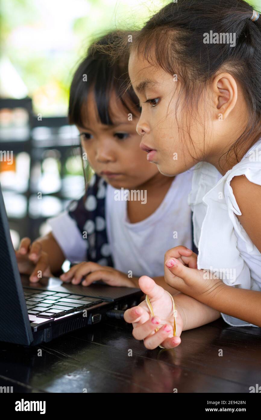 Laos, Don Dhet. Two girls taking a lesson through a computer Stock ...