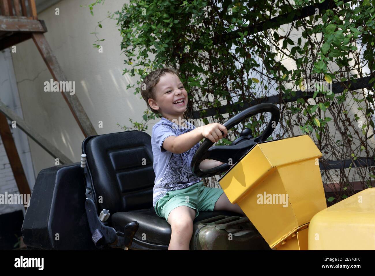 Happy boy driving a tractor at the farm Stock Photo - Alamy