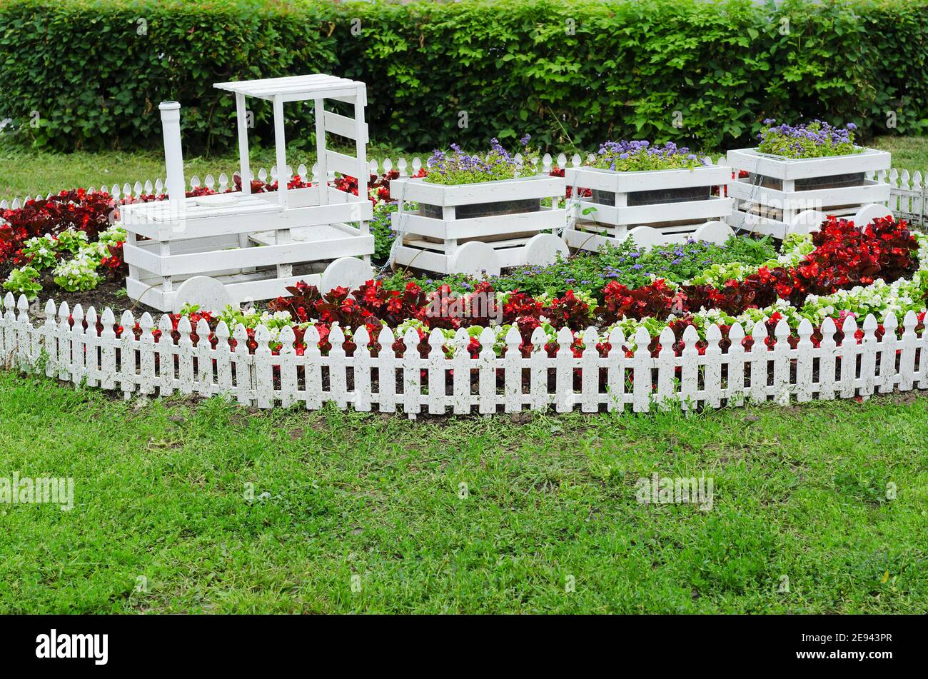 Creative flowerbed with flowers in the form of a train of boxes, on a ...