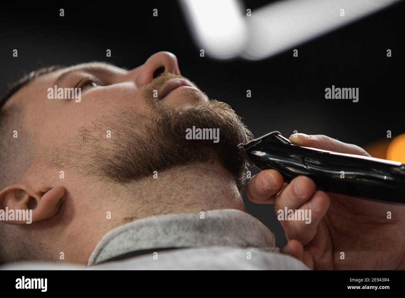 Close up of client of master barber, stylist during getting care and ...