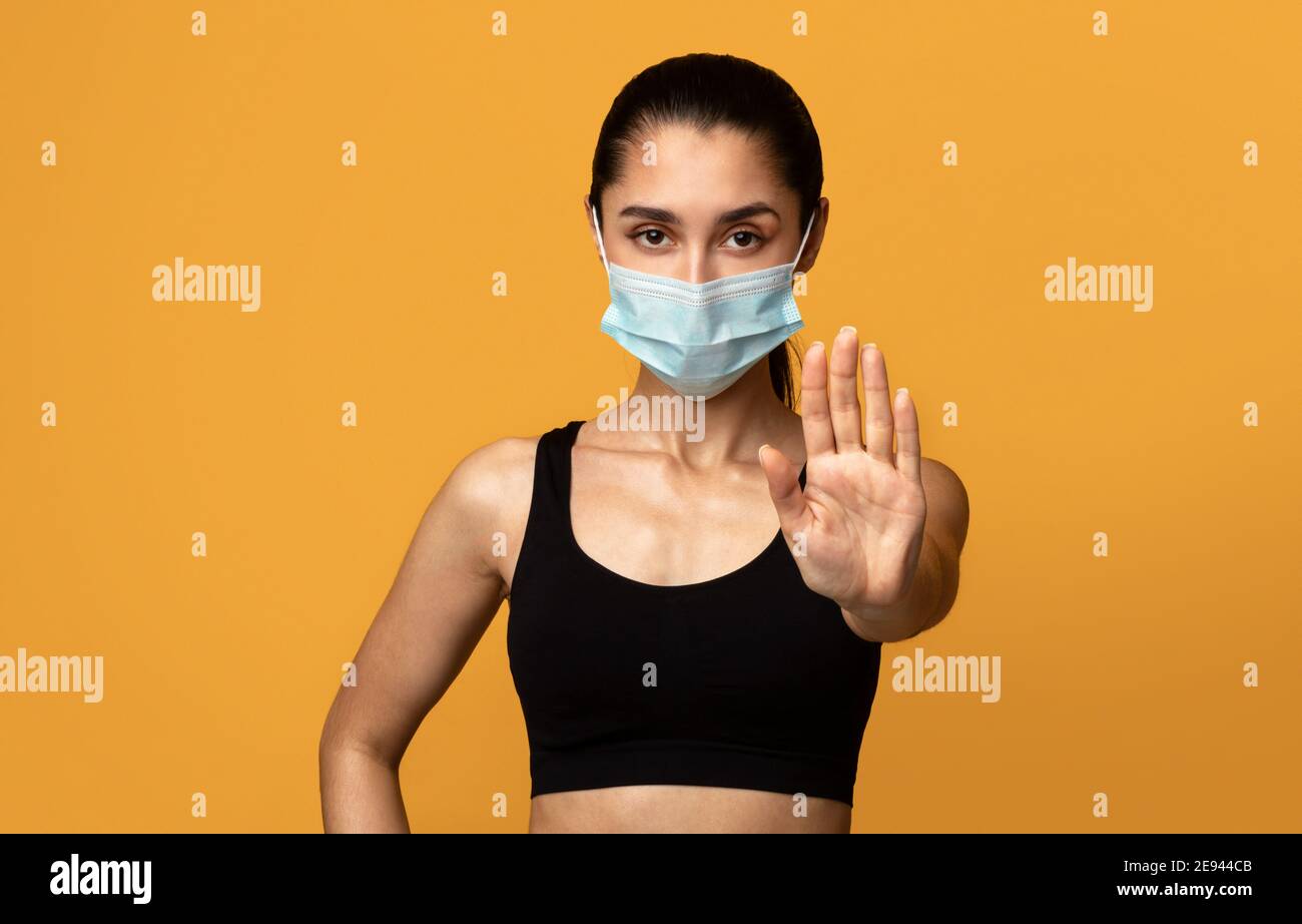 Woman wearing protective face mask showing stop sign Stock Photo - Alamy