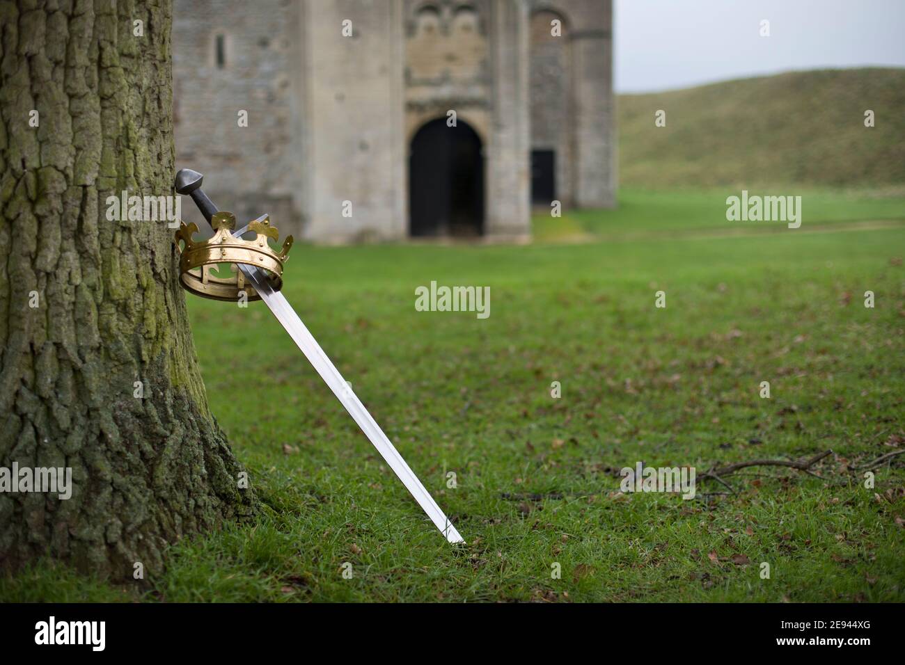 Crown and sword rest against tree outside castle keep Stock Photo - Alamy
